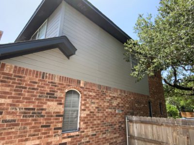 Red Brick House With Gray Siding and Dark Trim - SurePRO Painting