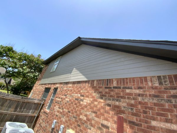 Red Brick House With Gray Siding and Dark Trim - SurePRO Painting
